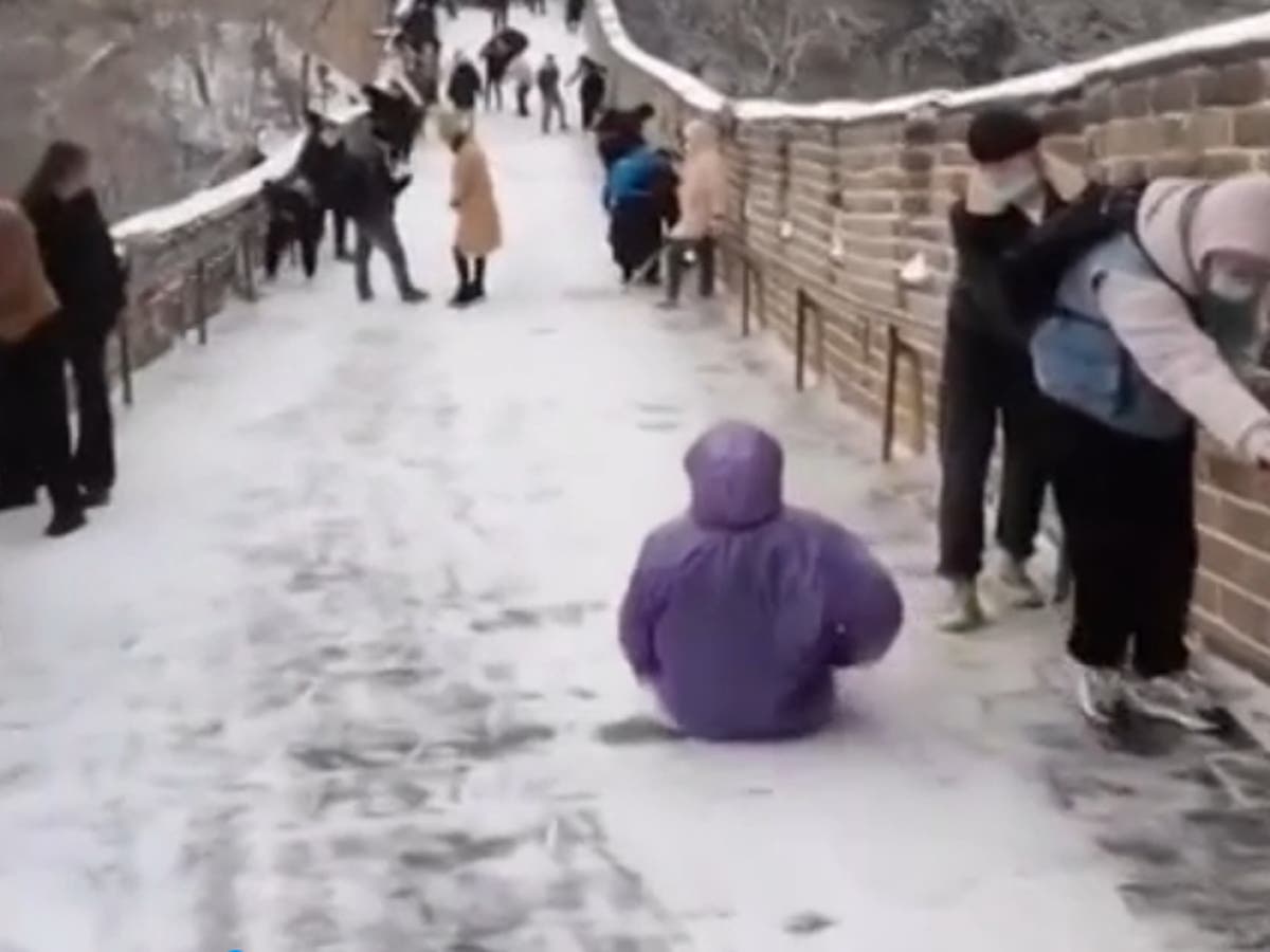 Tourist slides down Great Wall of China in icy conditions | The Independent