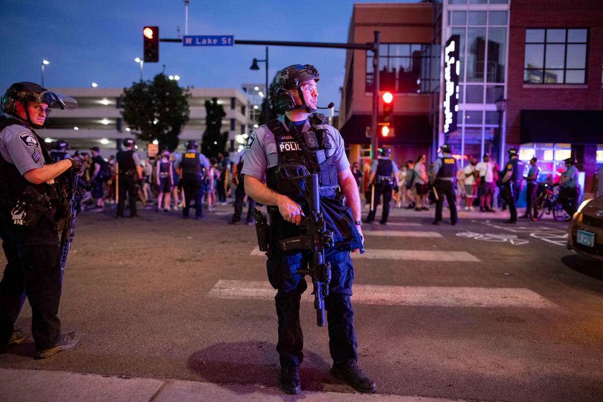 Police with assault rifles and silencers clear out memorial to slain ...