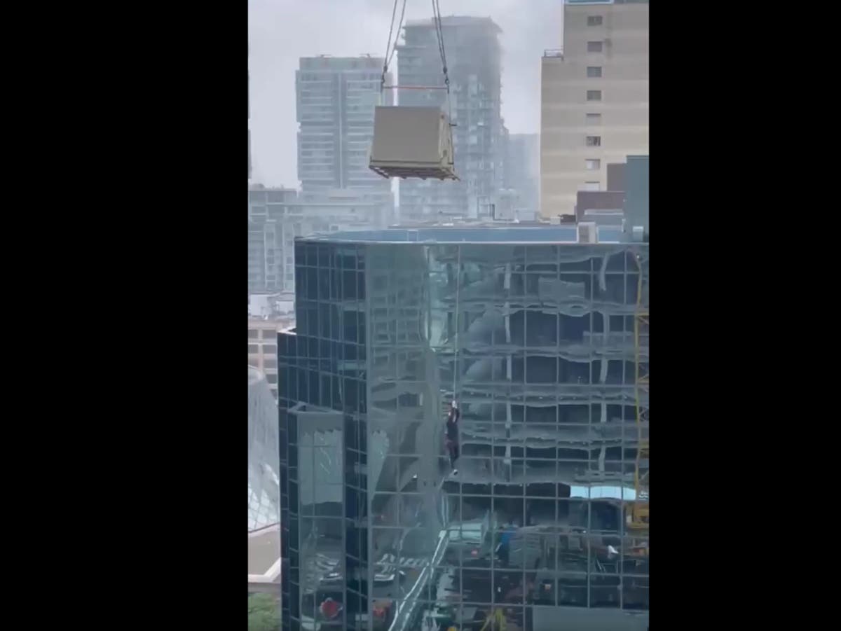 Horror video shows construction worker hanging by one hand after crane ...