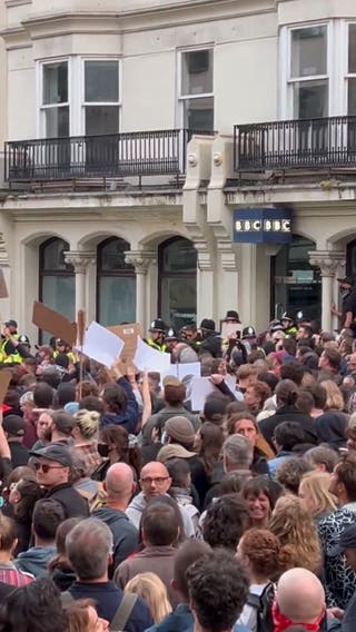 Four protestors hide behind police barrier amid huge anti-racist ...