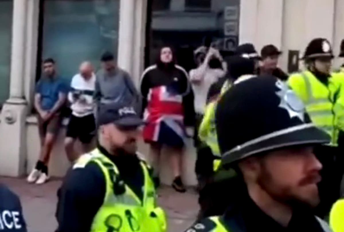 Four protestors hide behind police barrier amid huge anti-racist ...