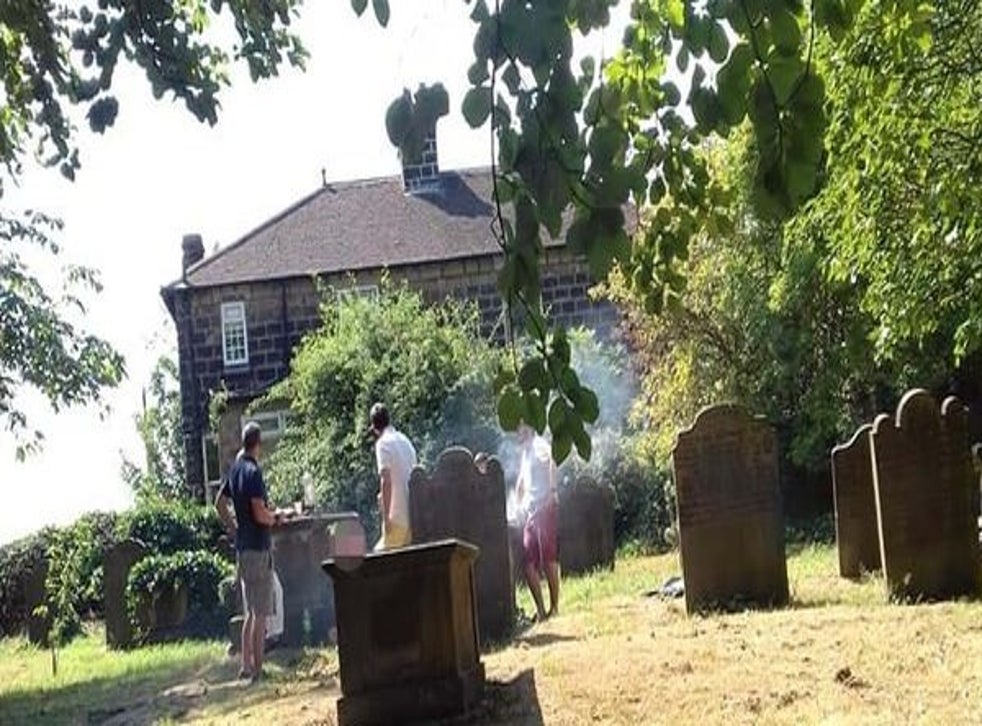 A group were photographed having a barbecue in a cemetery and people ...