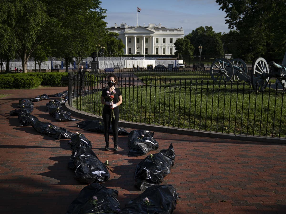 Protesters hold ‘Trump lies, people die’ signs and dump fake body bags ...